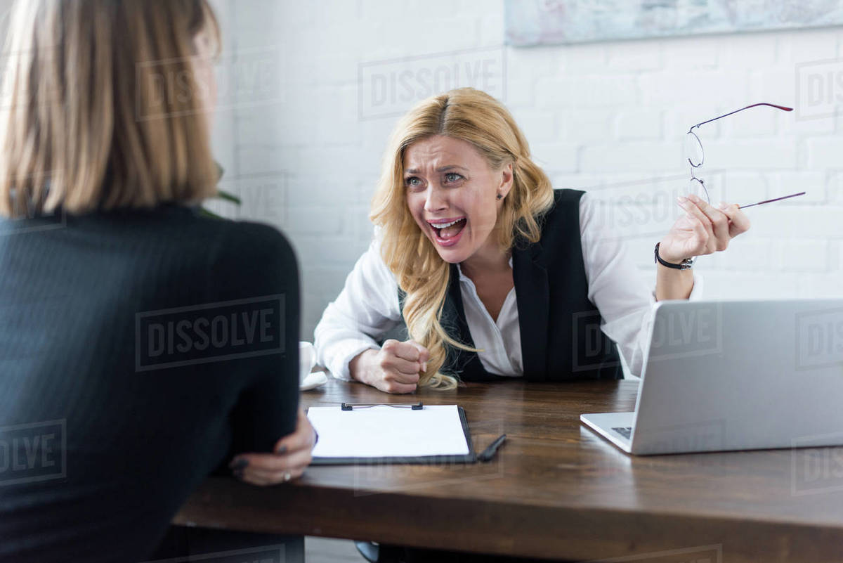 Angry businesswoman screaming at coworker in office - Stock Photo ...