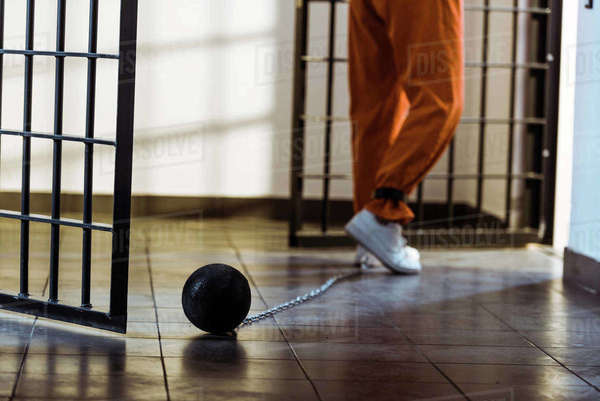 Cropped image of prisoner walking in orange uniform with weight ...
