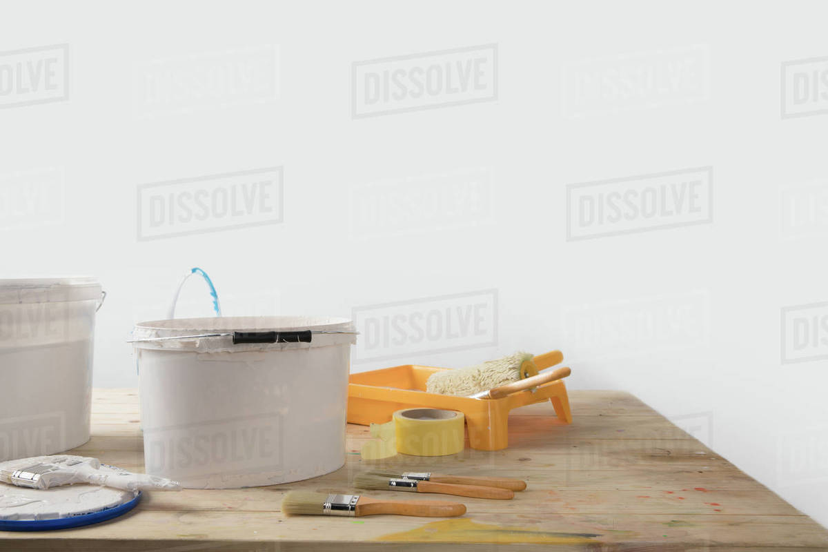 Buckets with paints and plastic tray on wooden table - Stock Photo ...