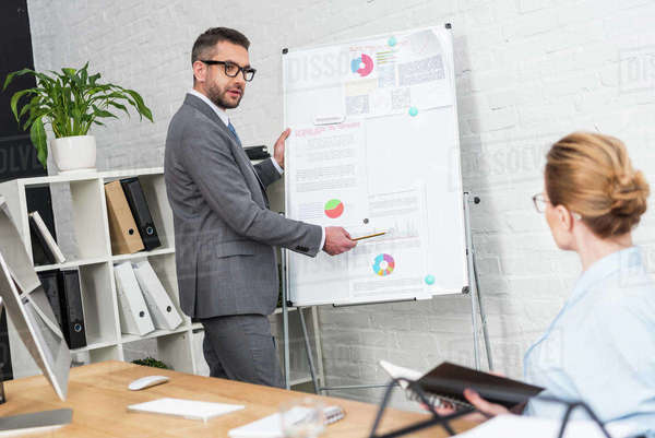 Businessman making presentation with whiteboard for colleague at office ...