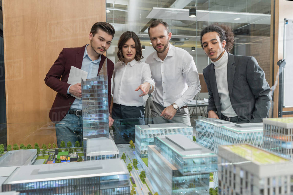 Group of architects discussing building models at office - Stock Photo ...