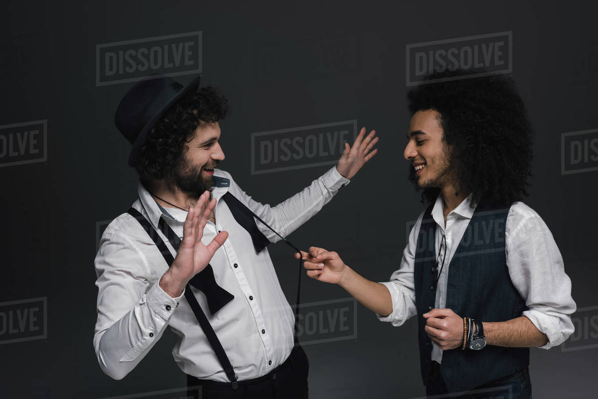 Stylish young men having fun on black - Royalty-free Stock Photo | Dissolve