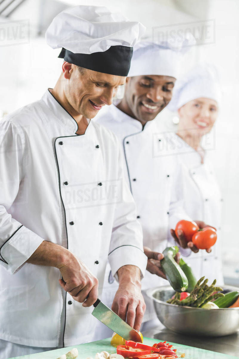 Smiling multicultural chefs cooking at restaurant kitchen - Royalty ...