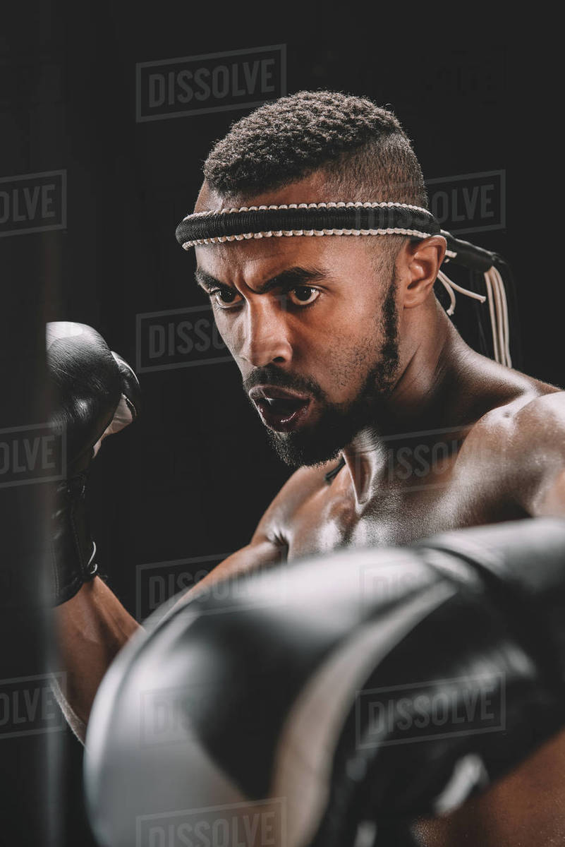 portrait of focused muay thai fighter training isolated on black ...