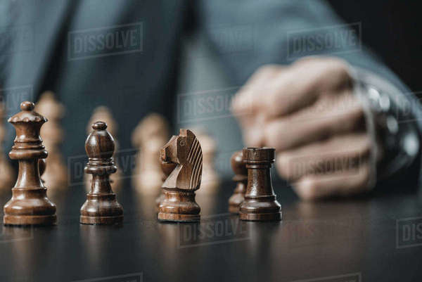 selective focus of wooden chess figures on table and businessman ...