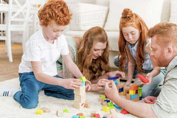 beautiful redhead family playing with constructor on floor at home ...