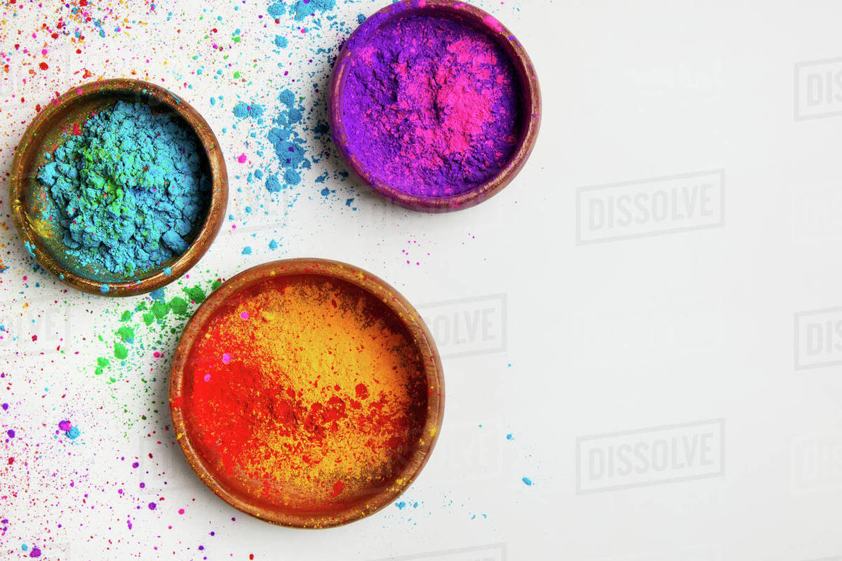 Top view of colorful traditional holi powder in bowls isolated on white ...