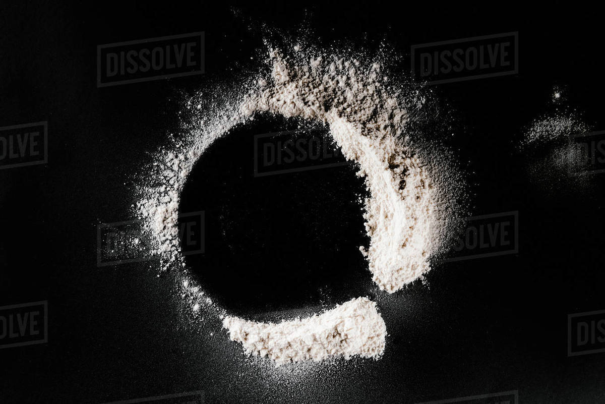 Top view of flour on black tabletop - Stock Photo - Dissolve