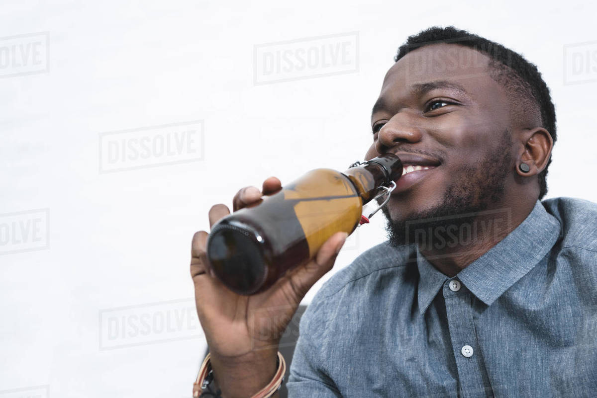 Handsome African American man drinking beer from bottle - Royalty-free ...