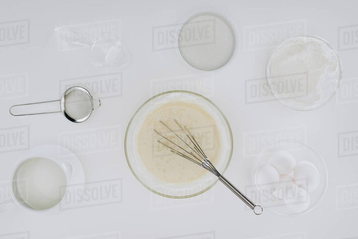 Top view of dough and whisk, ingredients and utensils for cooking ...