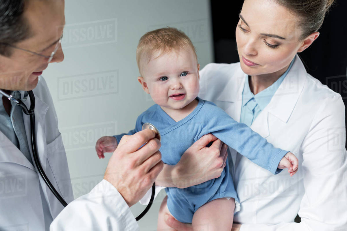 Close-up shot of smiling pediatricians checking breath of smiling ...