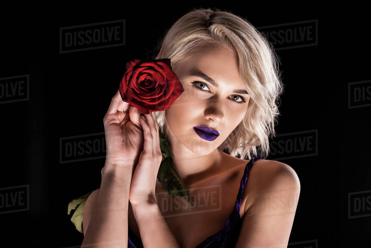 Attractive girl posing with red rose flower, isolated on black ...