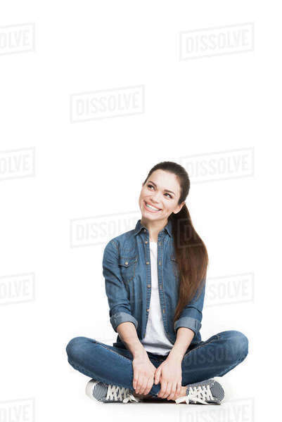 Attractive smiling woman sitting in jeans, isolated on white - Royalty ...