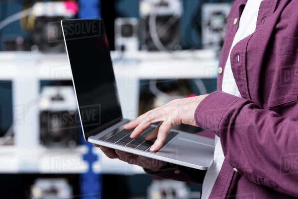 Cropped shot of computer engineer working with laptop at cryptocurrency ...