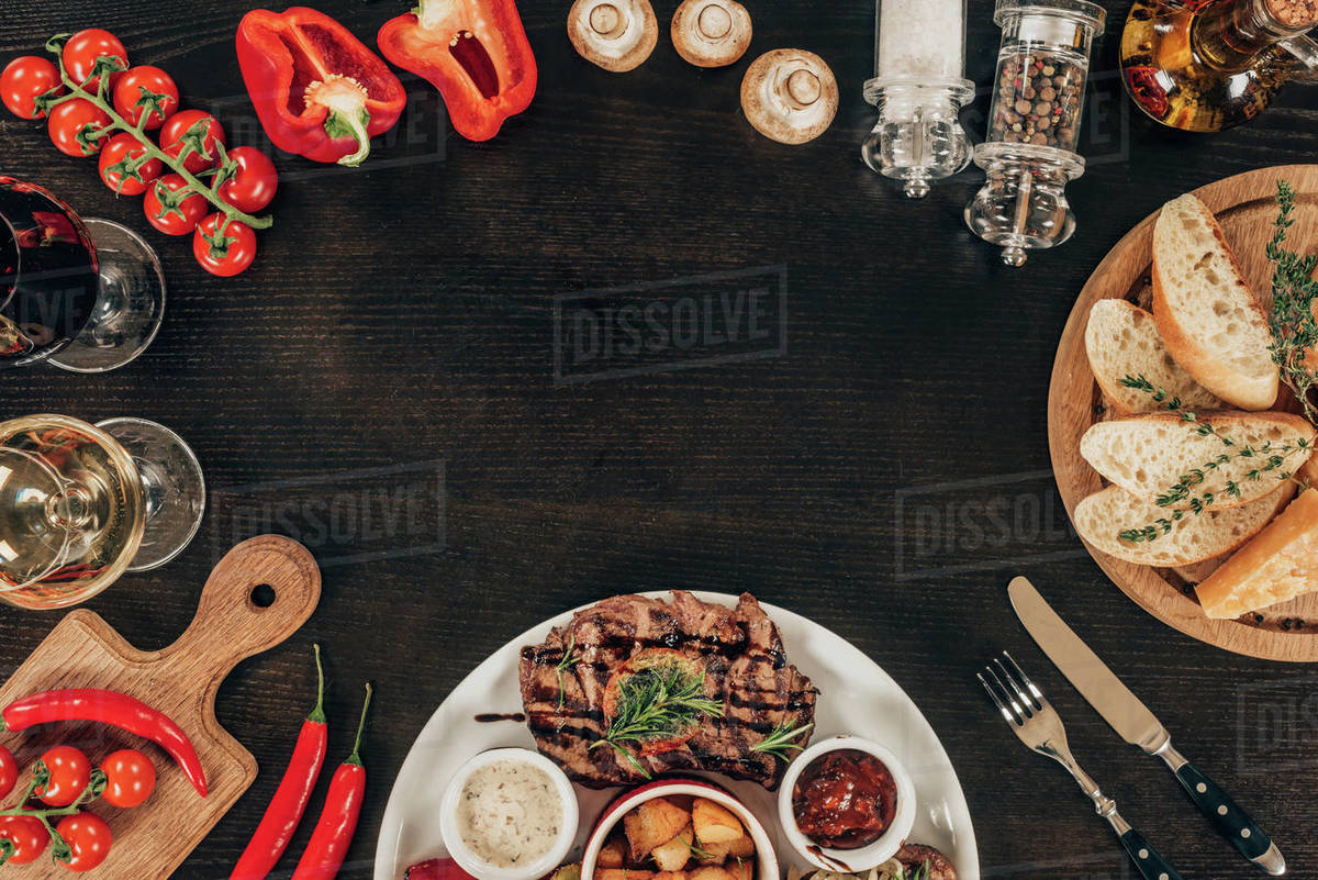 Top view of fresh vegetables and cooked beef steak on table - Stock ...