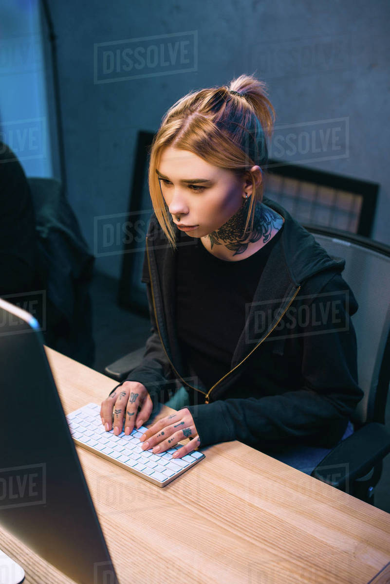 High angle view of serious young female hacker developing malware ...