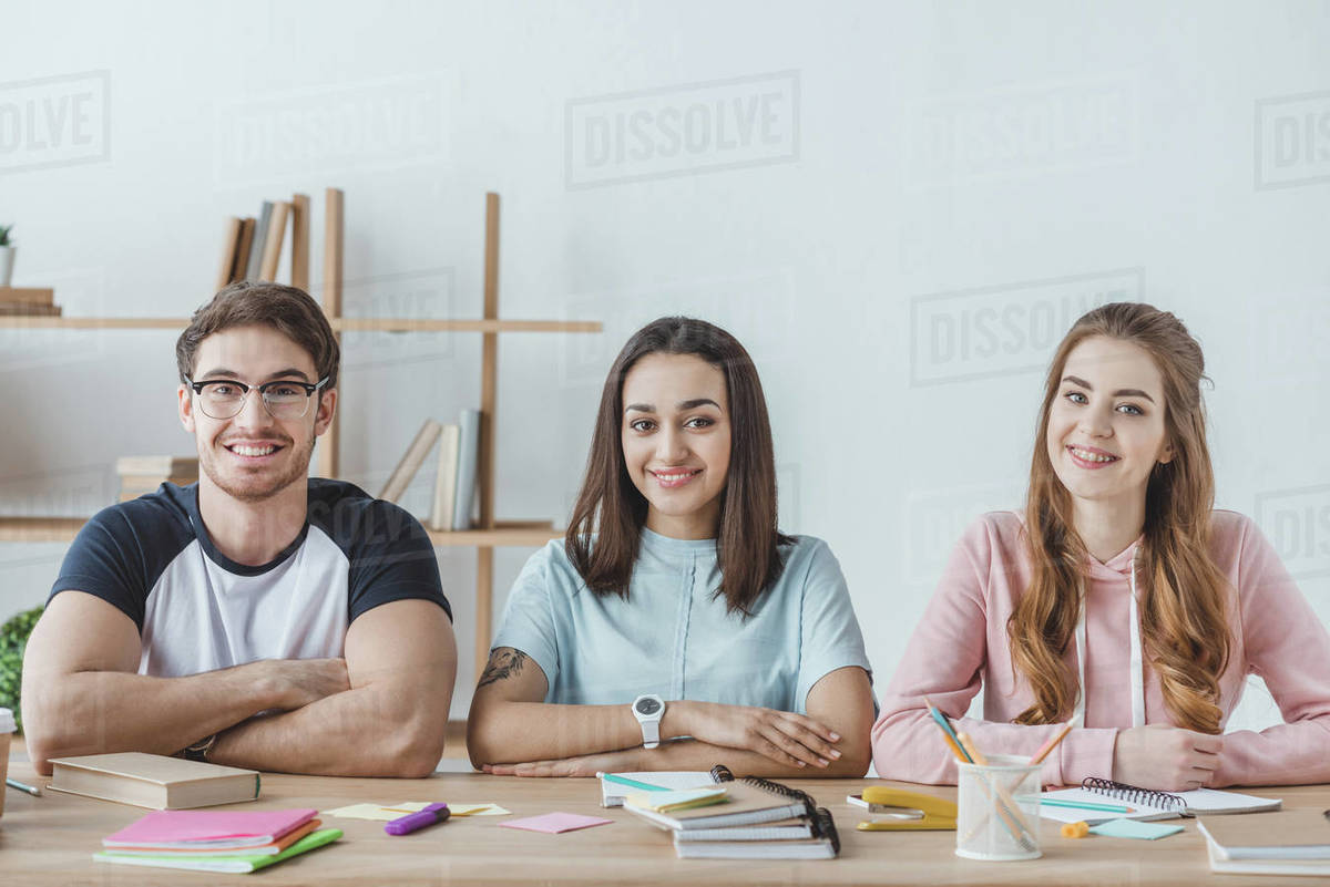 Young students sitting at table with books and copybooks - Royalty-free ...