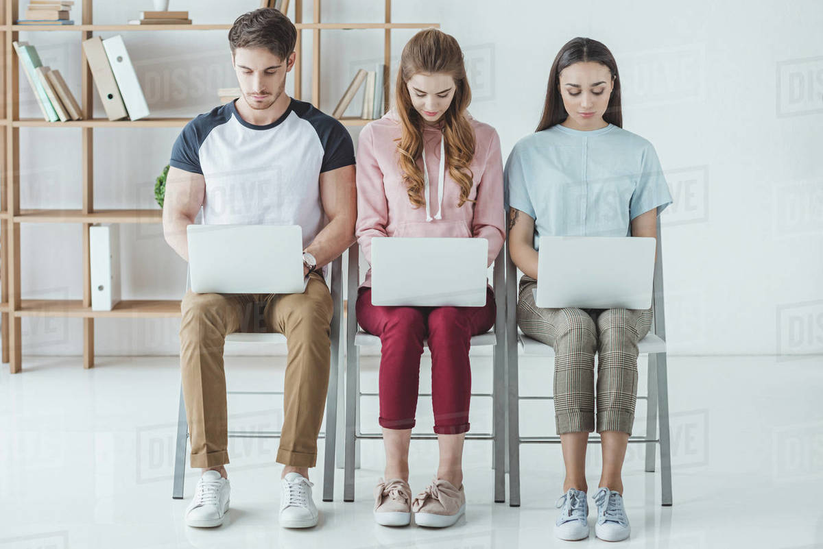Young students sitting and studying with laptops together - Royalty ...