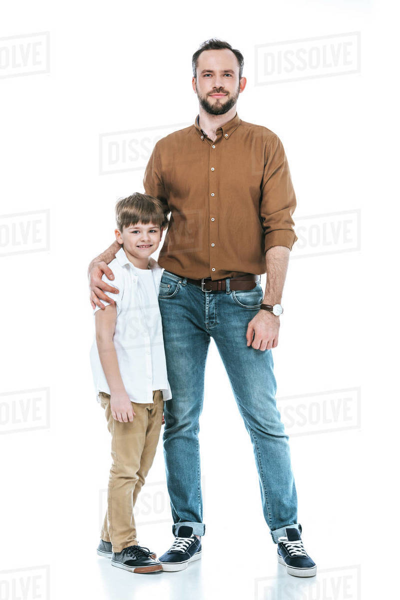 Full length view of happy father and son standing together and smiling ...