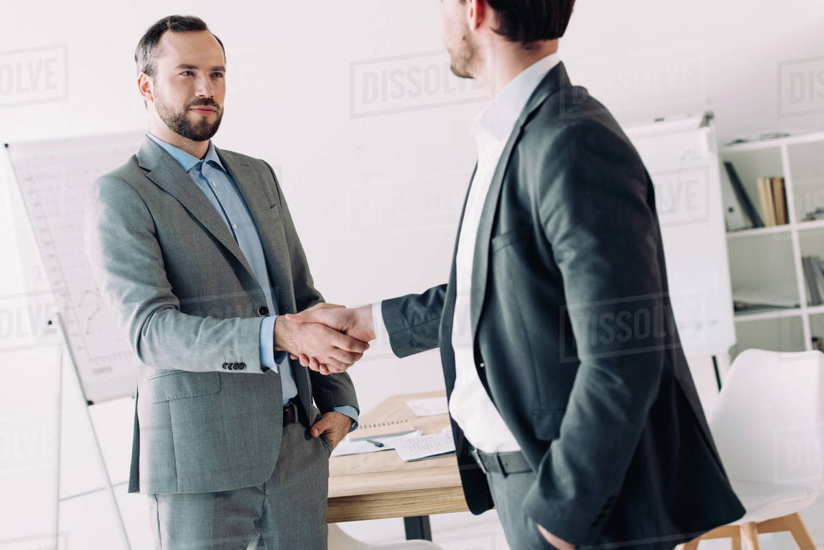 Handsome businessmen shaking hands in office - Royalty-free Stock Photo ...