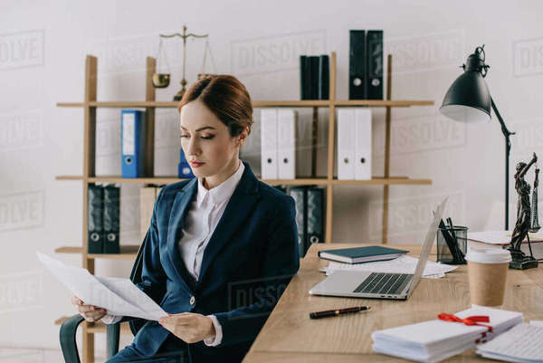 Female lawyer in suit with documents in hands at workplace in office ...