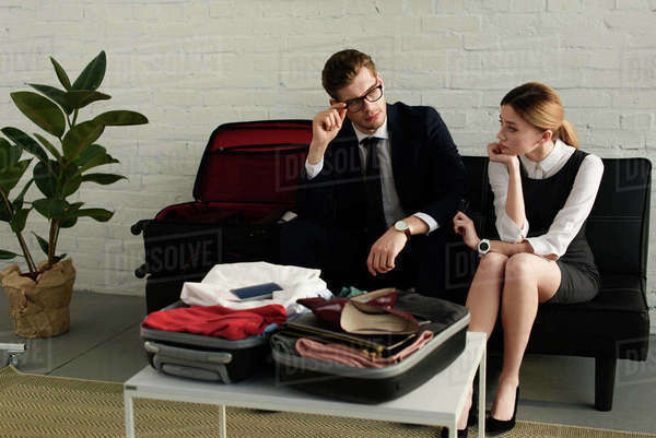 Sad colleagues packing suitcase for business trip - Royalty-free Stock ...