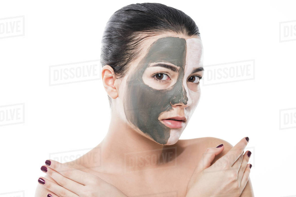Beautiful girl with different cosmetic facial masks looking at camera ...