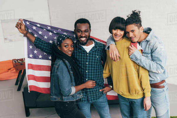 Four multiethnic friends standing with flag of usa - Stock Photo - Dissolve