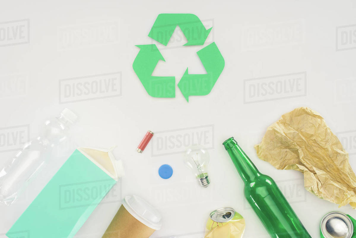 Top view of variation of types of trash with recycle sign on white ...