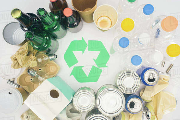 Top view of different types of trash with recycle sign on white ...
