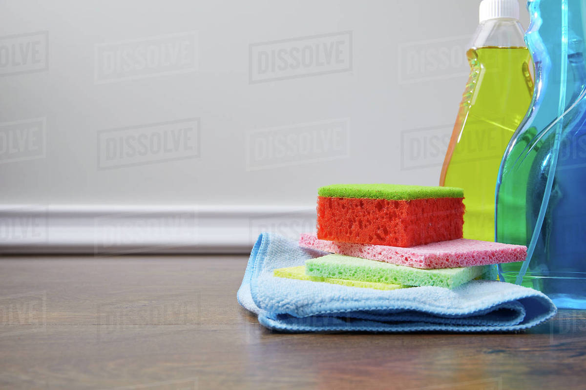 Bottles with antiseptic liquids and rags for spring cleaning on floor ...