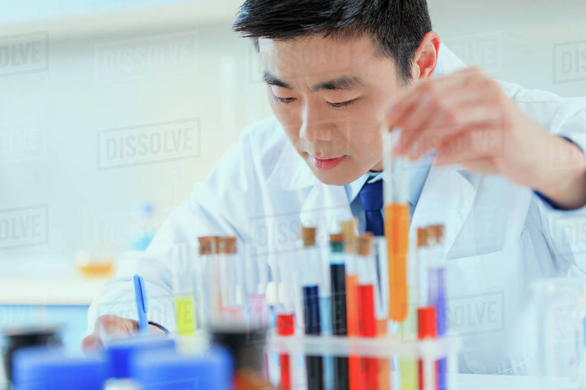 Young asian doctor in uniform working at testing laboratory, chemical ...