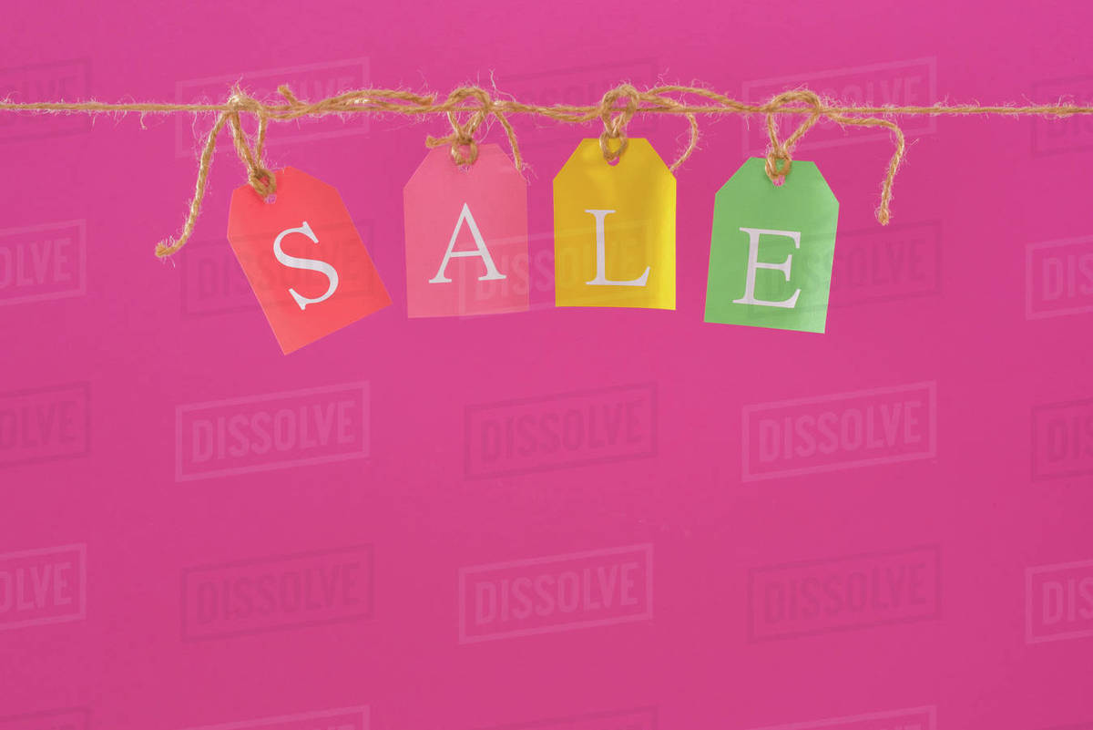 Close-up view of colorful sale sign on tags hanging on rope isolated on ...