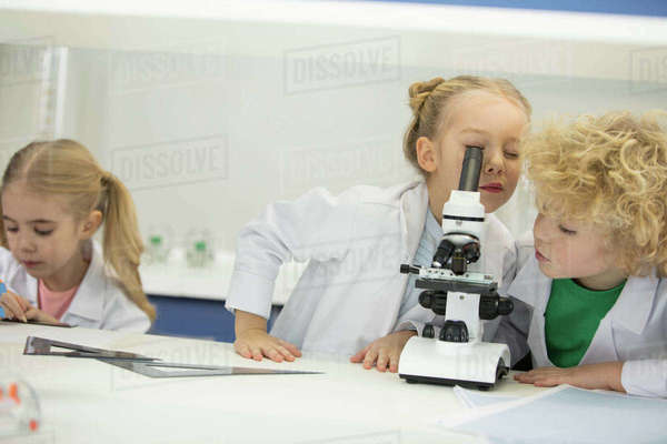 Little kids looking through microscope in science class - Stock Photo ...