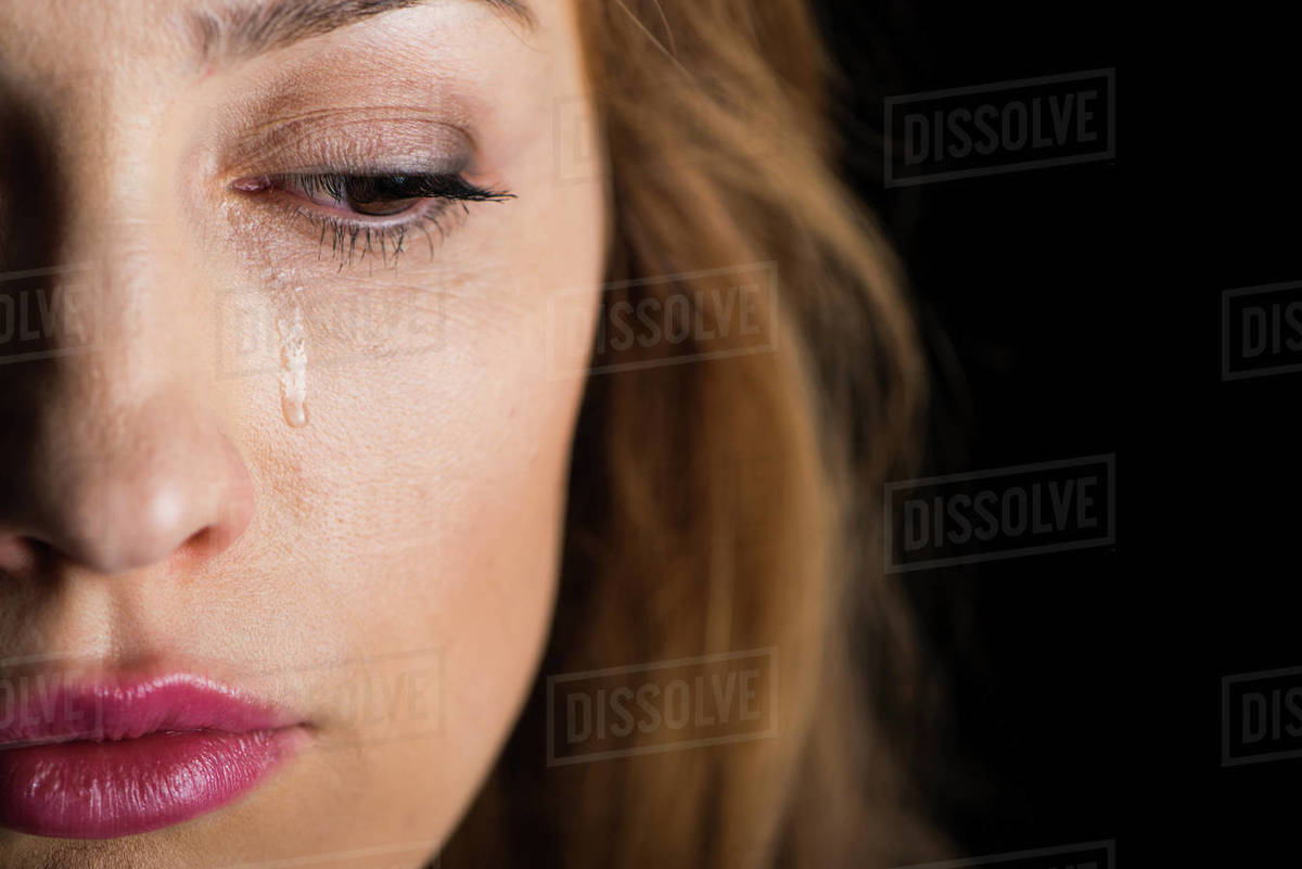 Close-up view of young crying woman's face isolated on black - Royalty ...