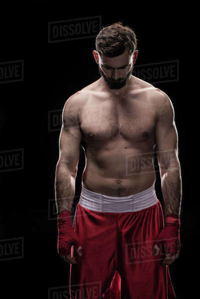 Young muscular bearded boxer with wrapping hands standing and looking ...