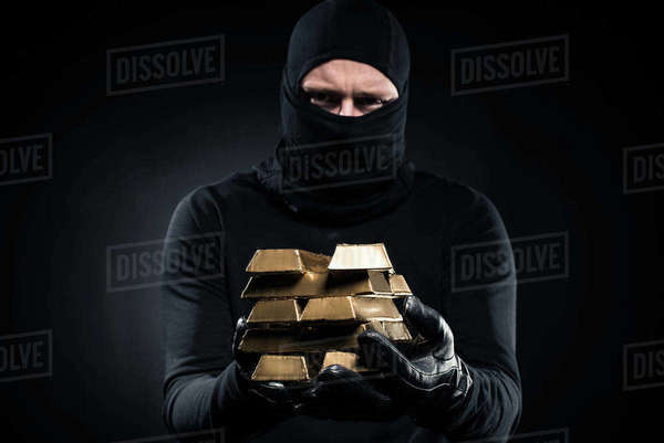 Man in balaclava holding gold bullions in his hands - Royalty-free ...