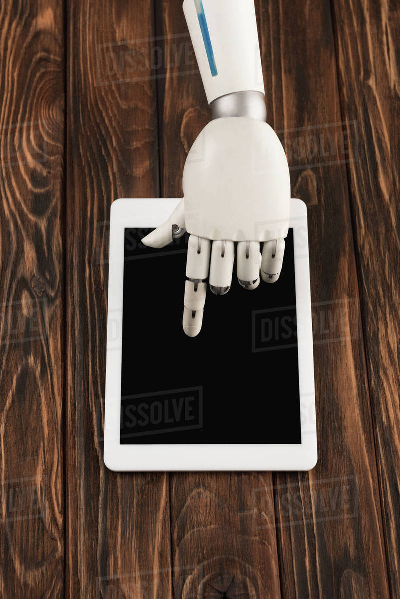 Cropped shot of robot touching screen of digital tablet on wooden ...