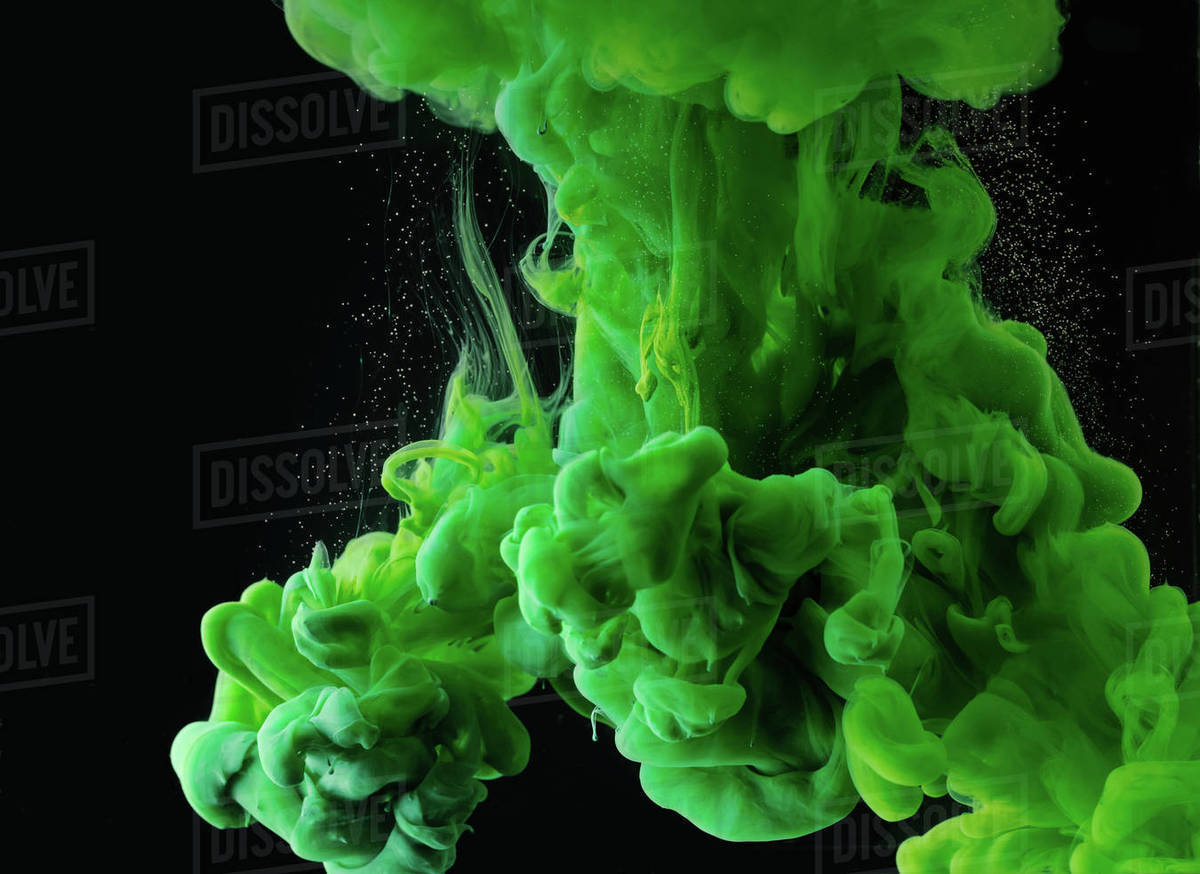 Close-up view of green abstract paint explosion on black background ...