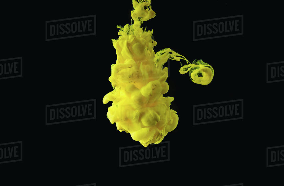Close-up view of bright yellow flowing ink on black background - Stock ...