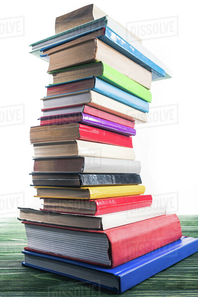 High bent tower of stacked books on wooden table - Royalty-free Stock ...