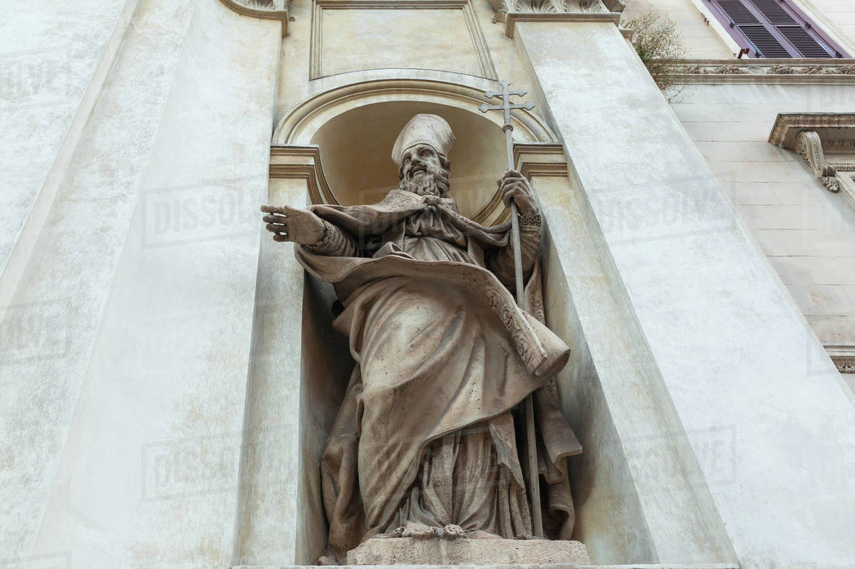 Religious statue on building facade in Rome - Stock Photo - Dissolve