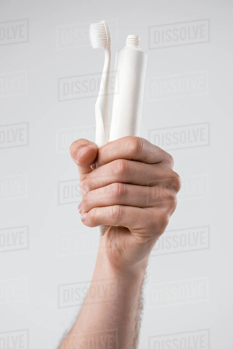 Cropped view of man holding toothbrush and toothpaste, isolated on ...