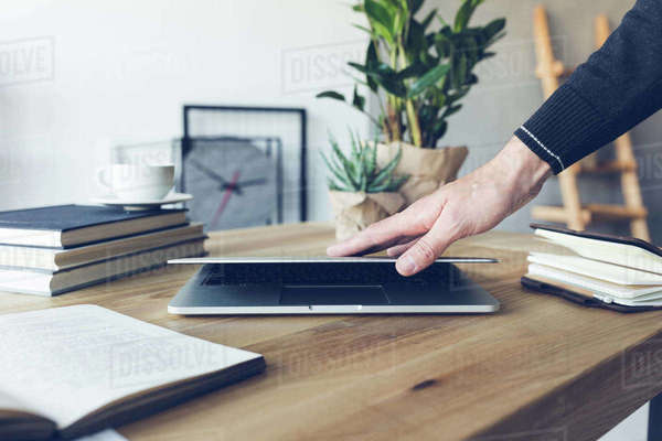 Human hand holding laptop at workplace in home office - Stock Photo ...