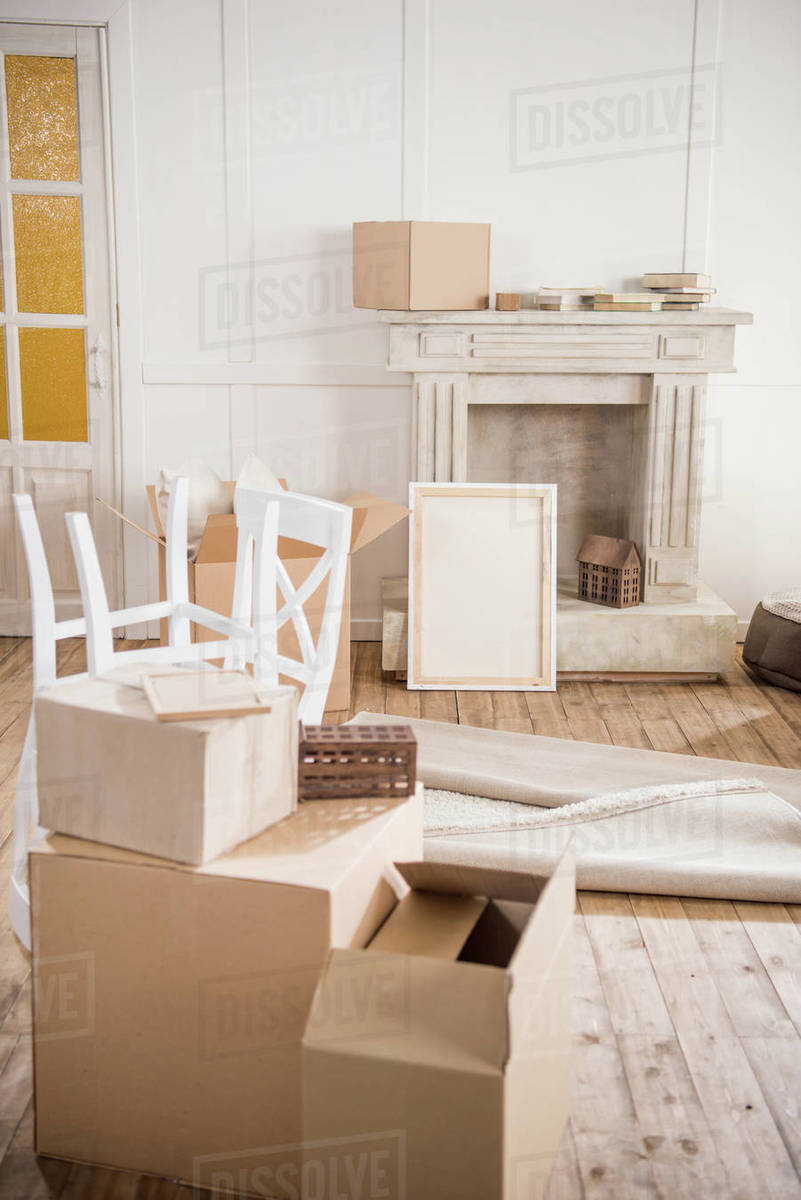 Cardboard boxes and furniture in empty room, relocation concept ...