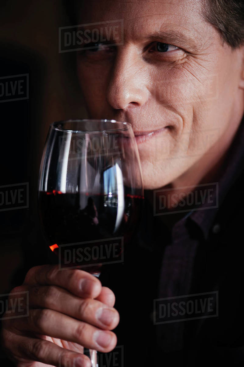 Handsome smiling man drinking wine and looking away - Stock Photo ...