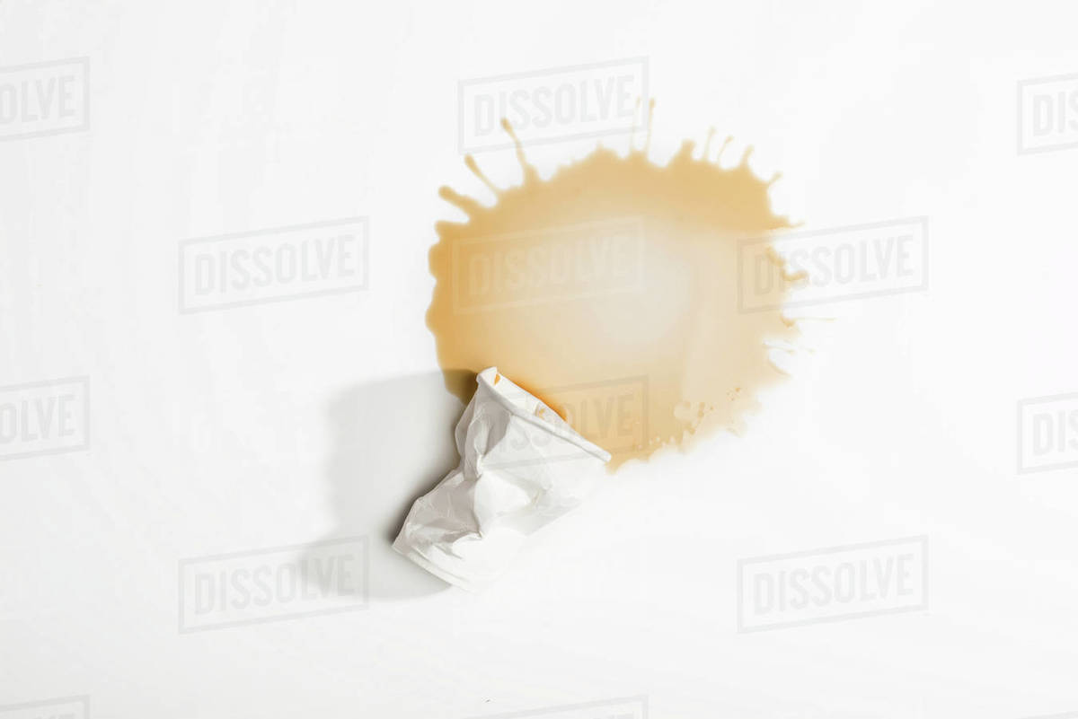 top view of crumpled used paper cup with spilled coffee isolated on ...