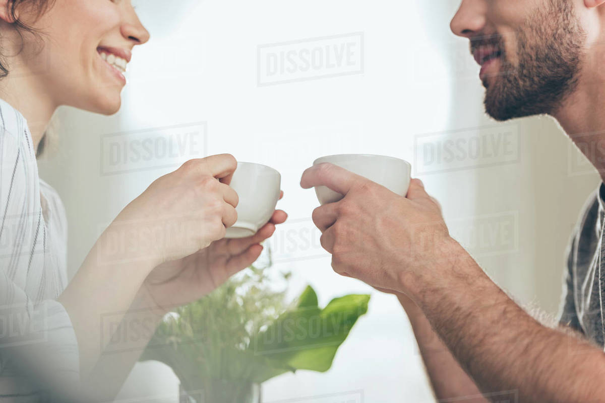 Cropped shot of happy young couple drinking coffee together at home ...