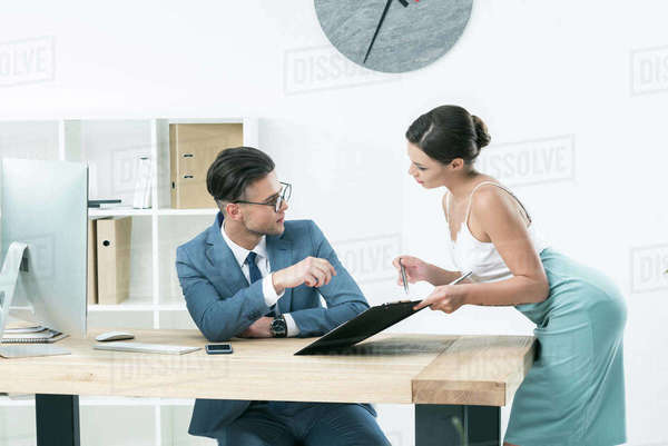 Young charming secretary talking to her boss at office - Stock Photo ...