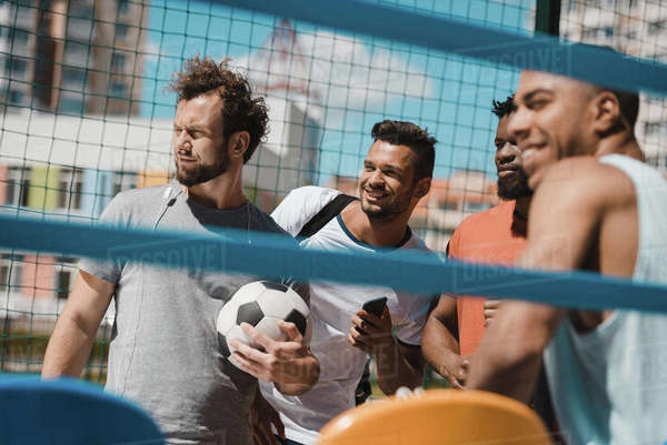 Multicultural soccer team resting on stadium together before game ...